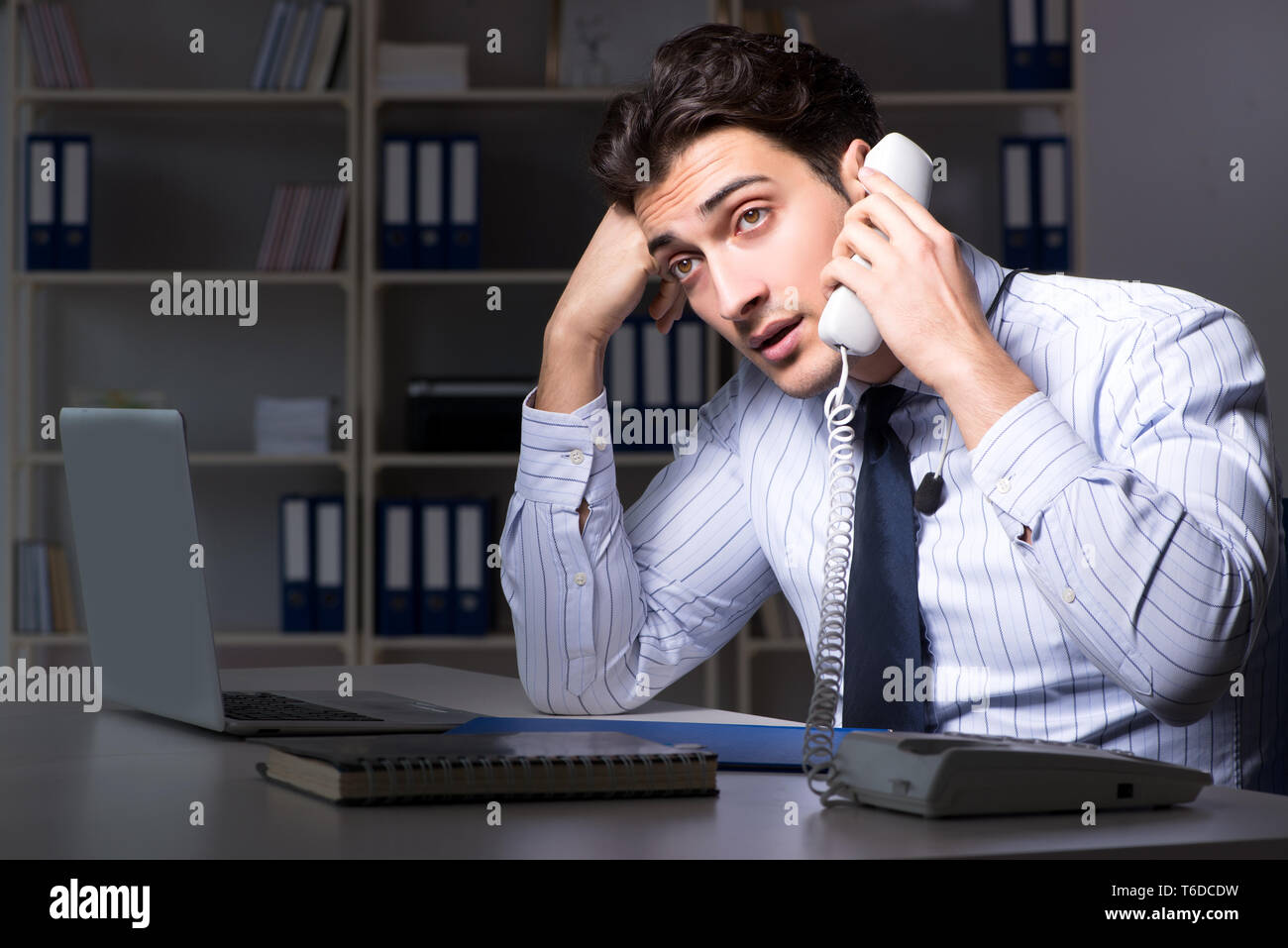 Tired and exhausted helpdesk operator during night shift Stock Photo ...