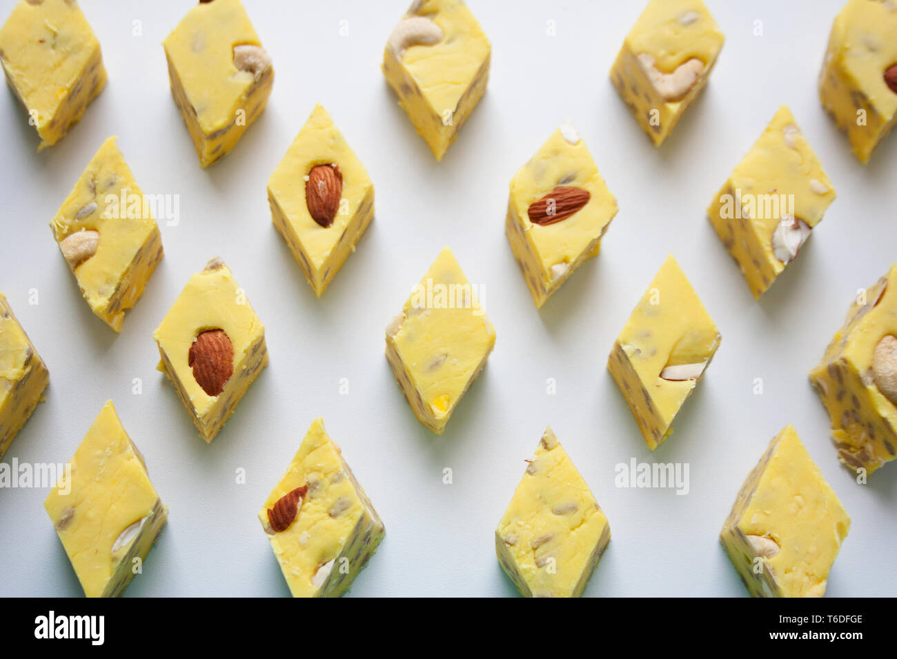 Yellow halva slices with almond and cashew nuts abstract rhombus ...