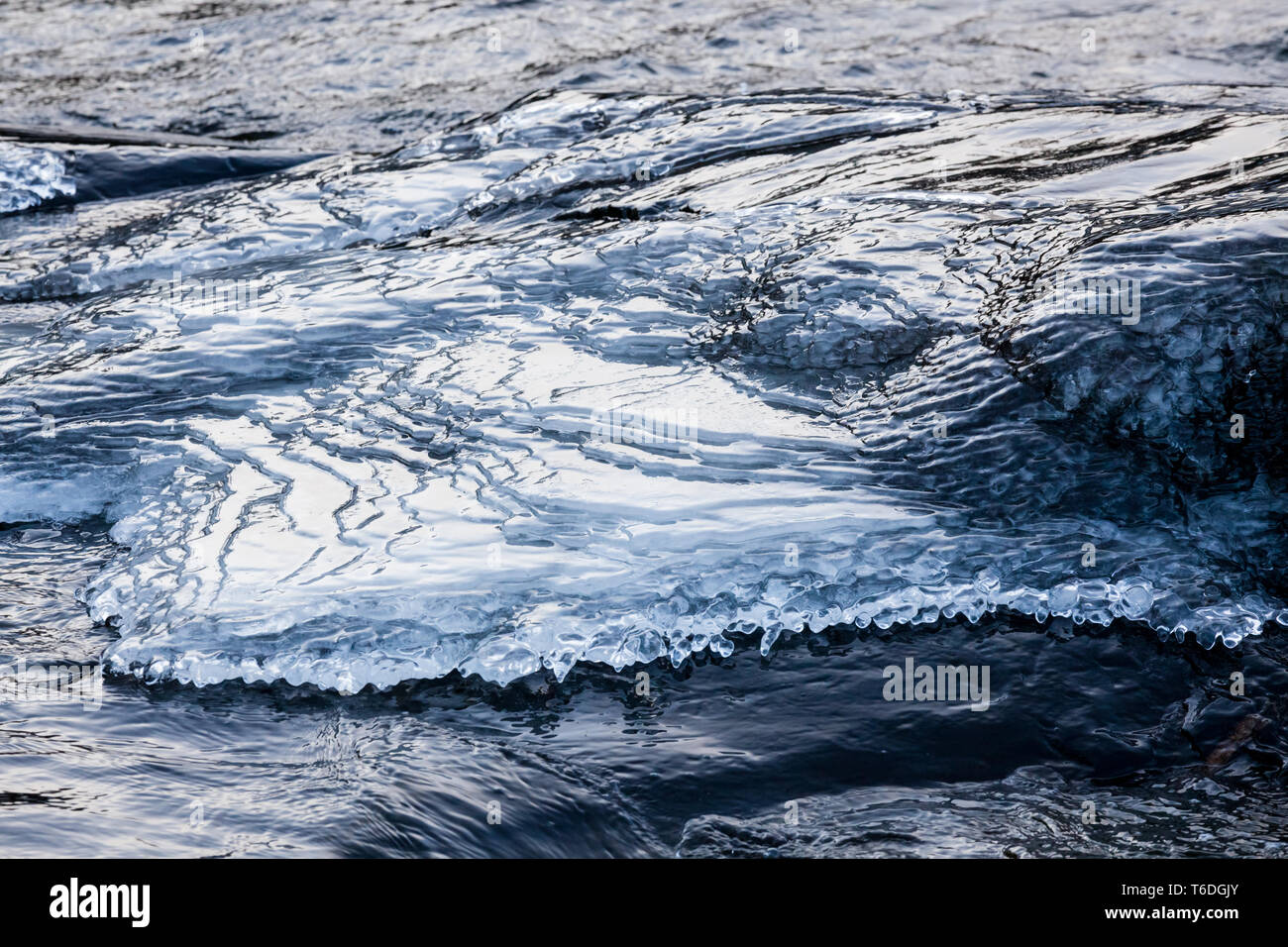 Ice frozen over rocks in lake shore Stock Photo - Alamy