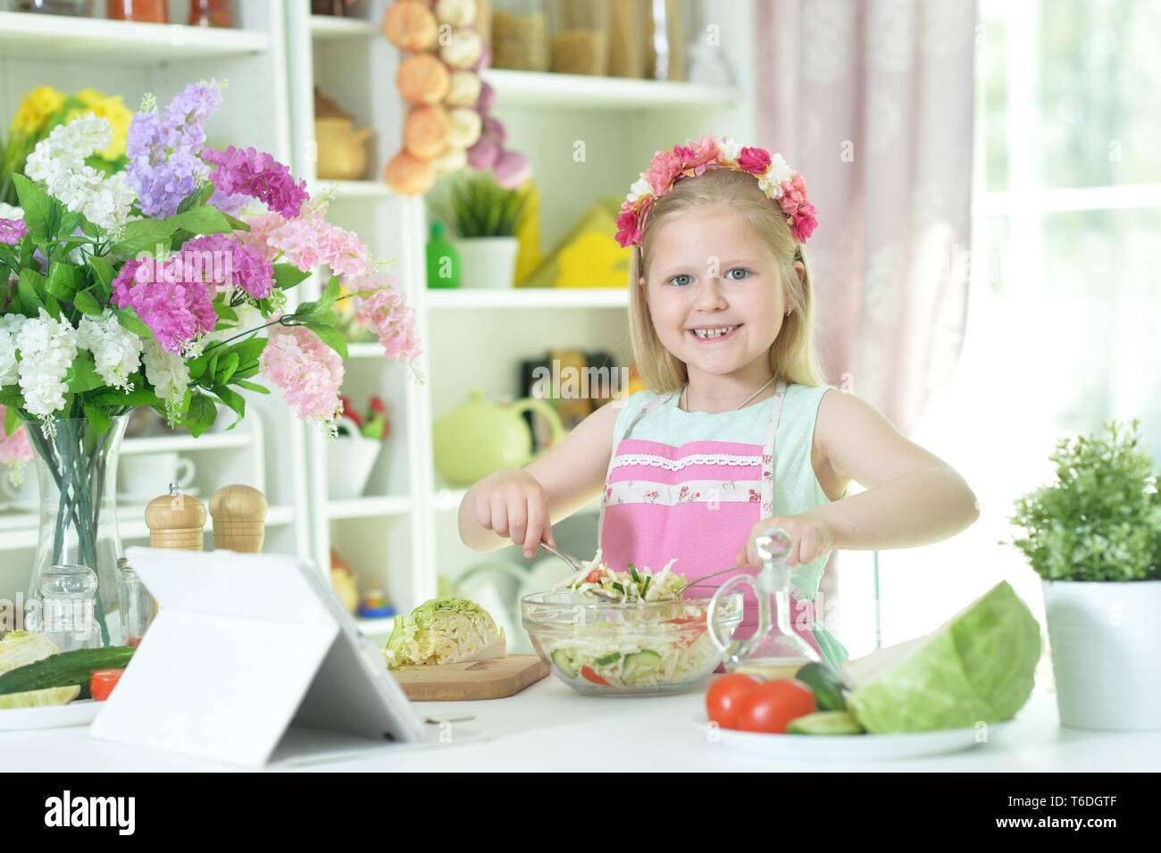 Portrait of cute little girl making dinner Stock Photo - Alamy