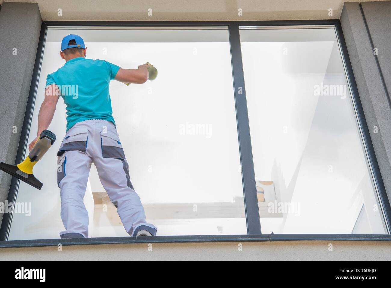 Caucasian Men Cleaning Large Residential Window Outside of the House ...