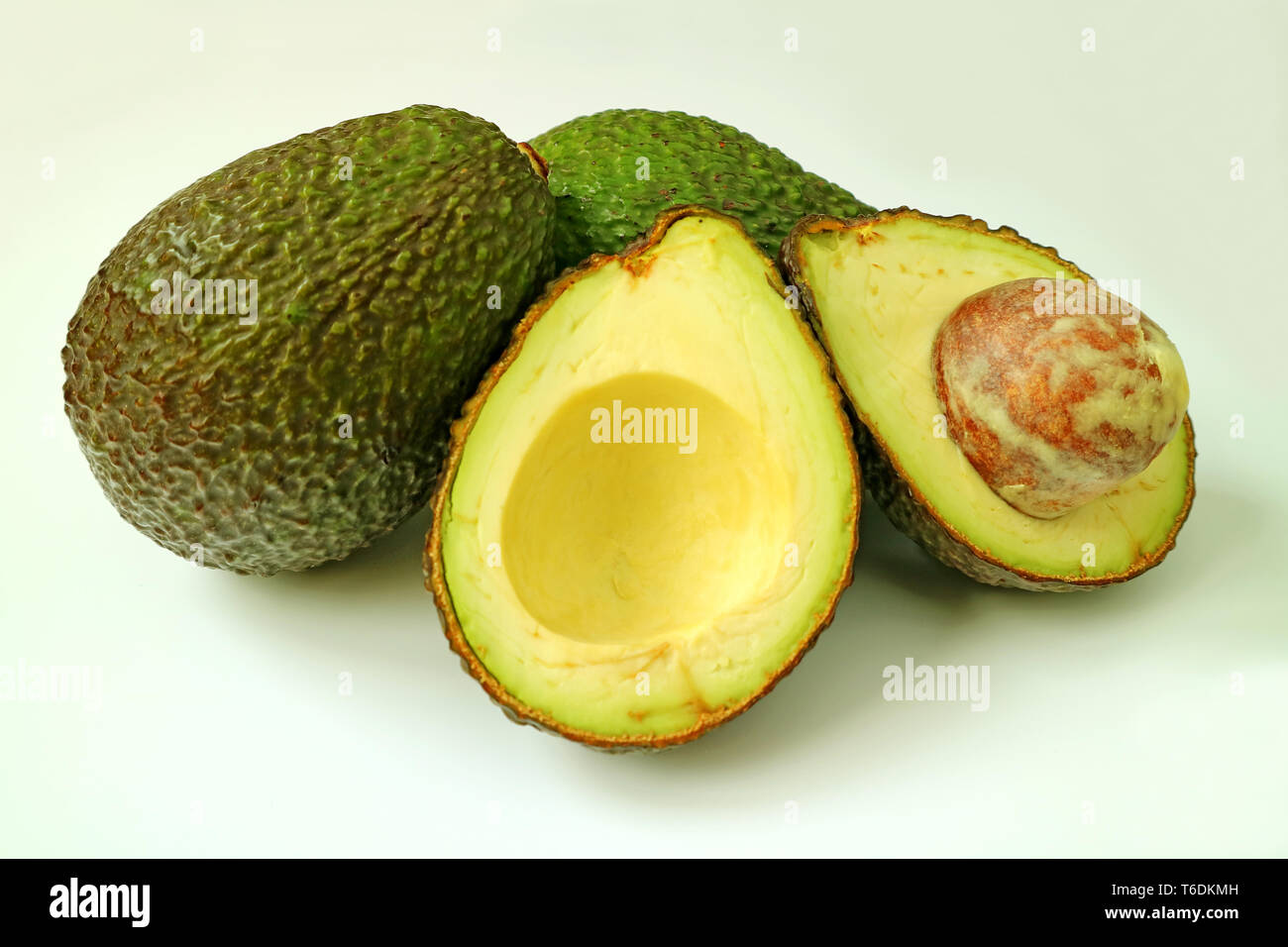 Fresh ripe avocado whole fruits and cut in half isolated on white ...
