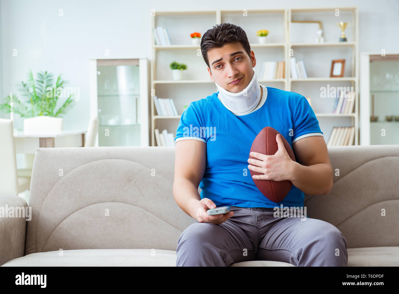 Man with neck injury watching american football at home Stock Photo - Alamy