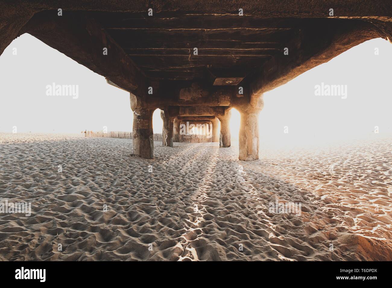 Underneath the wooden bridge at sandy beach Stock Photo - Alamy