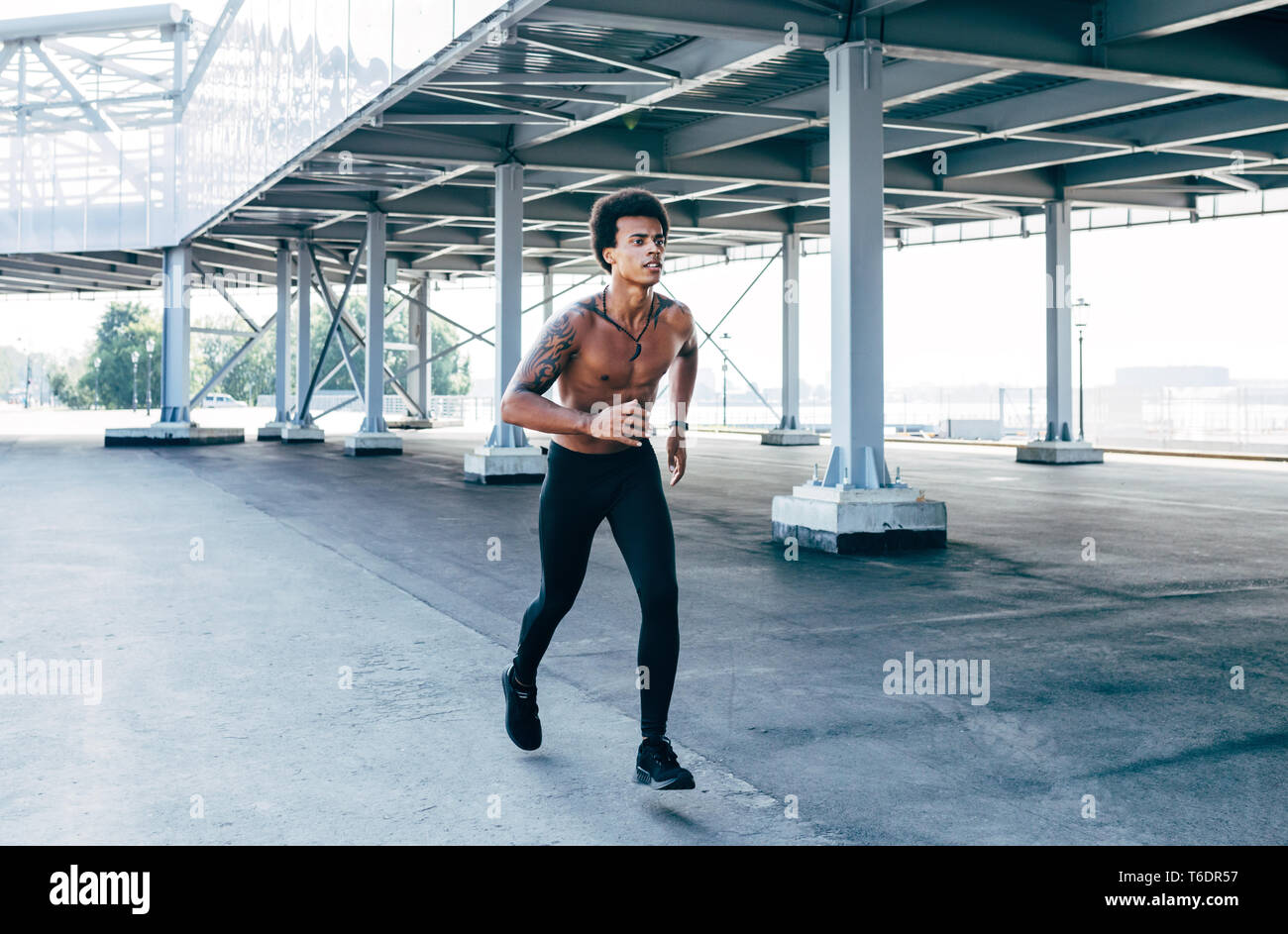 Young athlete with bare chest running outdoors Stock Photo - Alamy