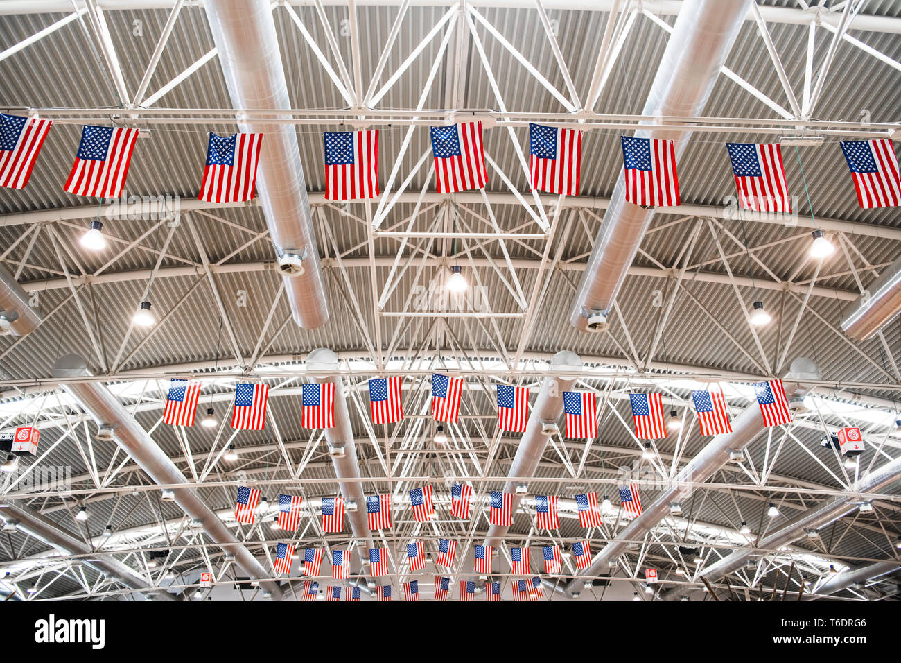 Many United States flags hanging on industrial hangar roof for ...
