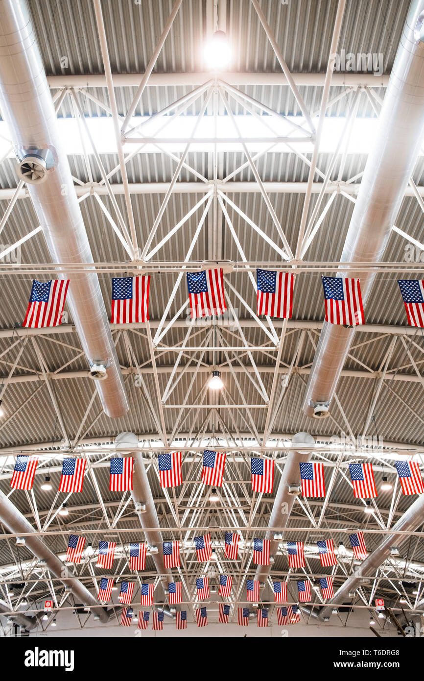Many United States flags hanging on industrial hangar roof for ...