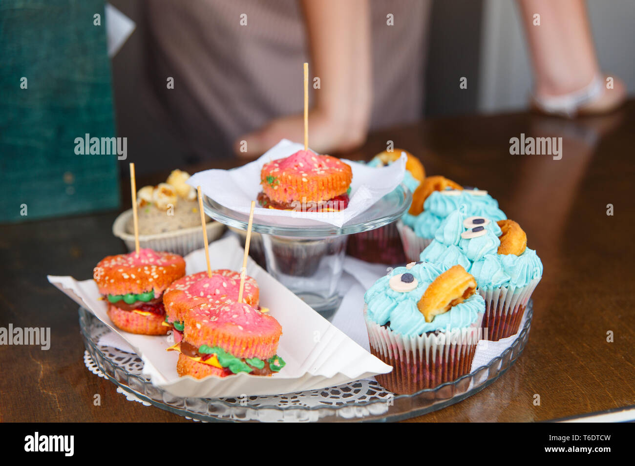 Cakes in the form of burgers and muffins on the counter cafe at the ...