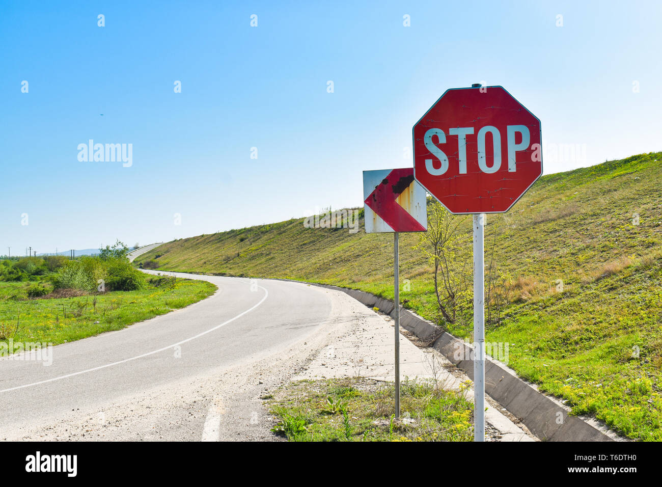 Stop sign in roads intersection Stock Photo - Alamy