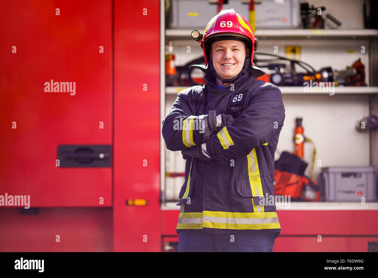 Image of smiling man firefighter in helmet on background of fire truck ...