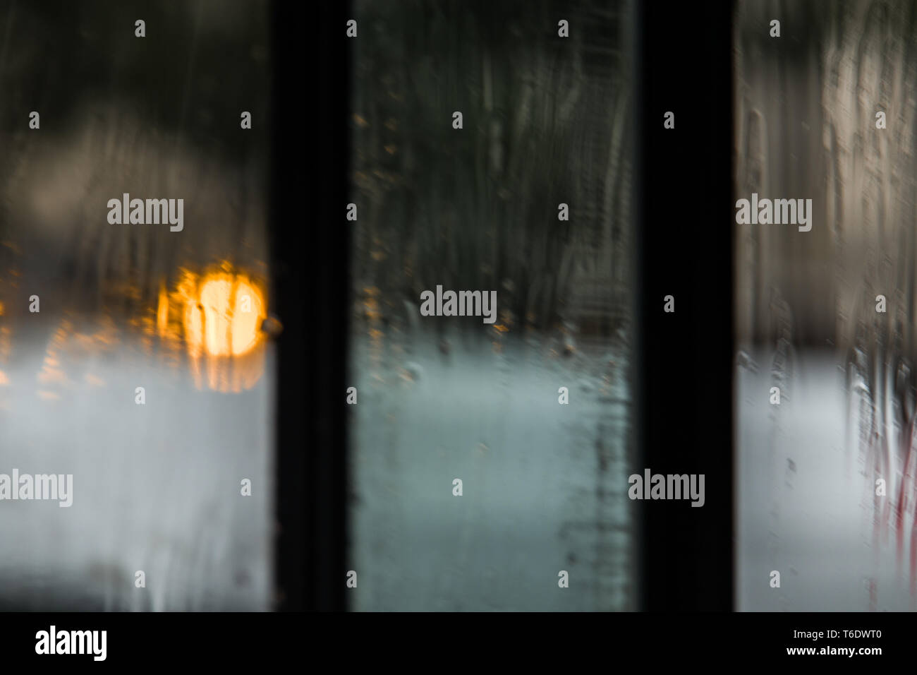 The rain rolls down the window of a coffee shop in Paris, France. A ...