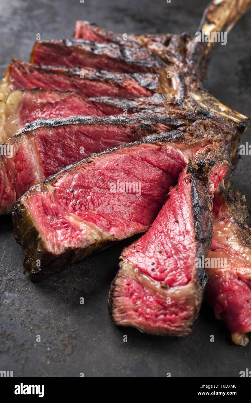 Barbecue dry aged Wagyu Tomahawk Steak sliced as close-up on old metal ...