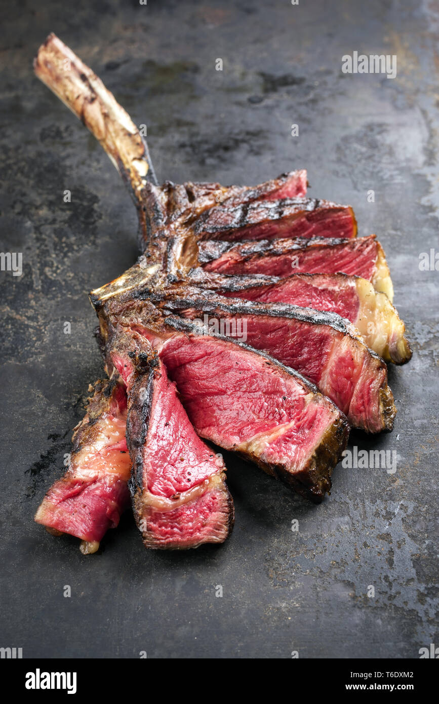 Barbecue dry aged Wagyu Tomahawk Steak sliced as close-up on old metal ...