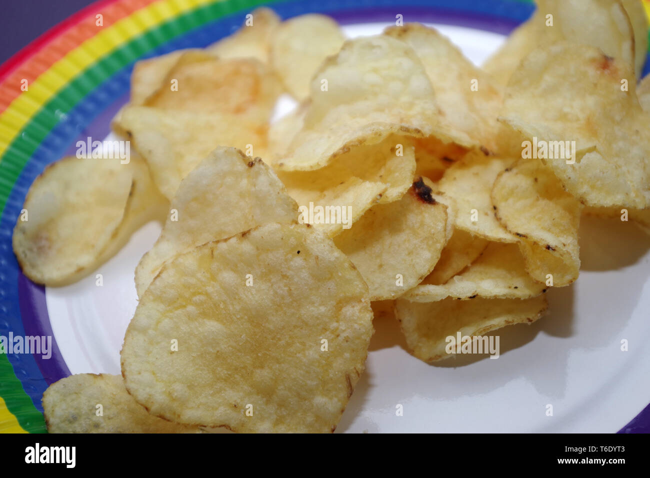 Crisps on a rainbow party paper plate Stock Photo - Alamy