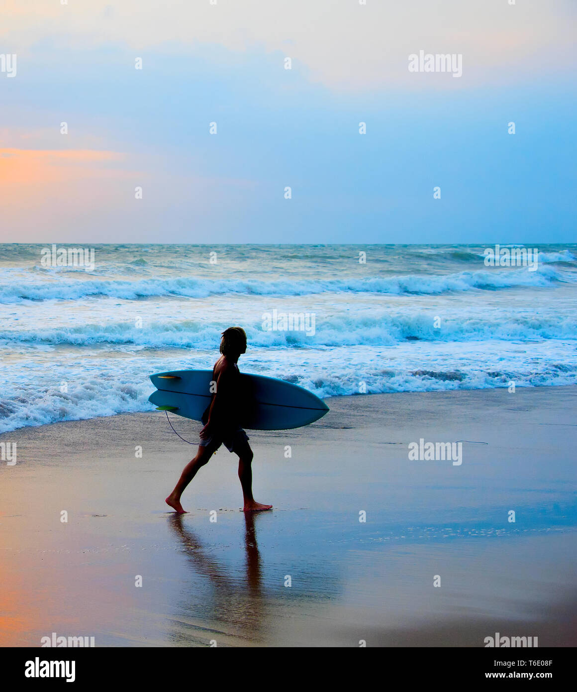 Surfer at beach with surfboard Stock Photo - Alamy