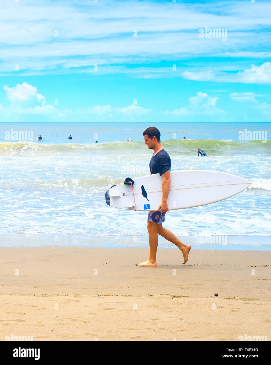 Man walk surfboard surfing beach Stock Photo - Alamy