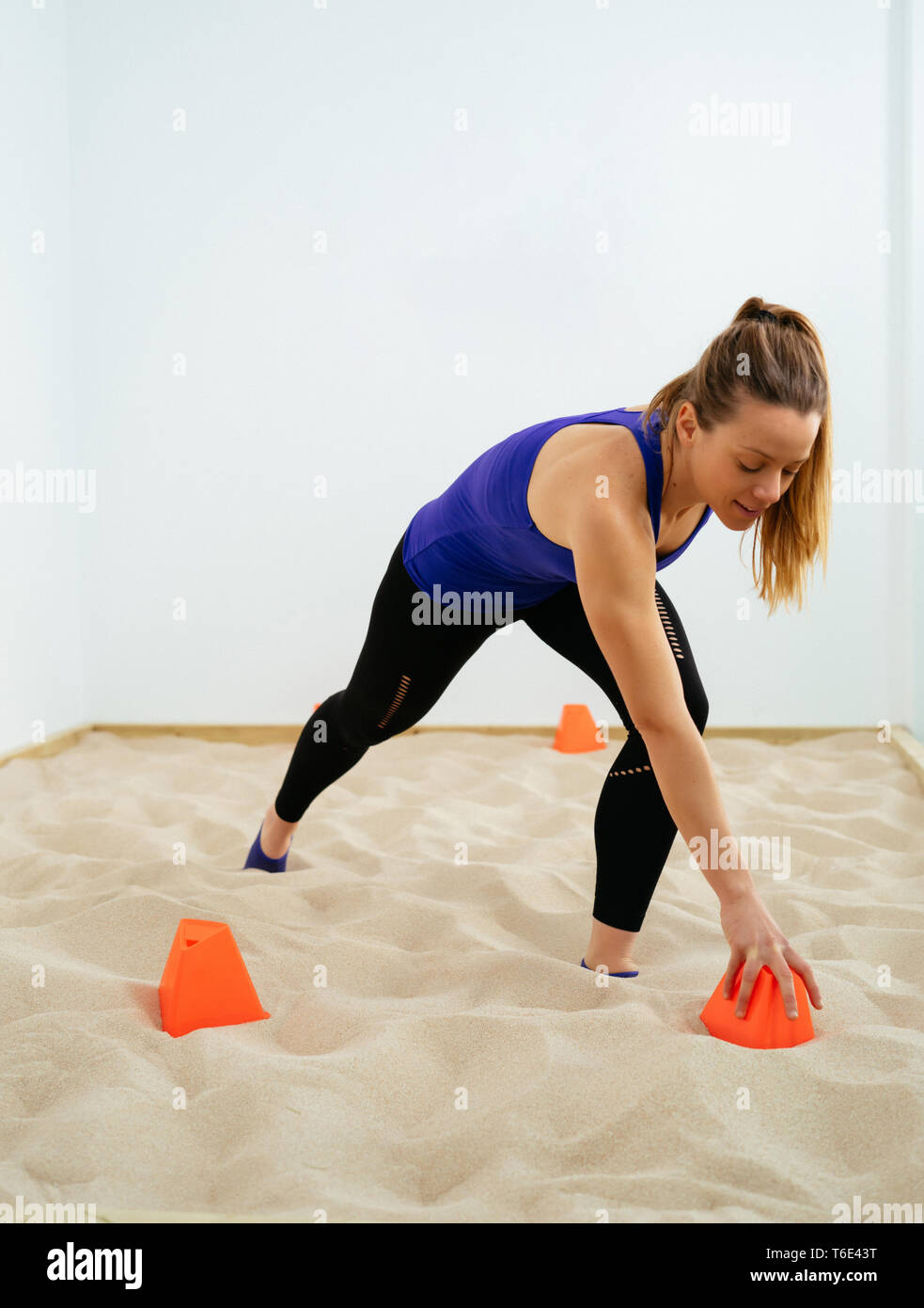 Young woman training on silica sand in a gym to recover the feet ...