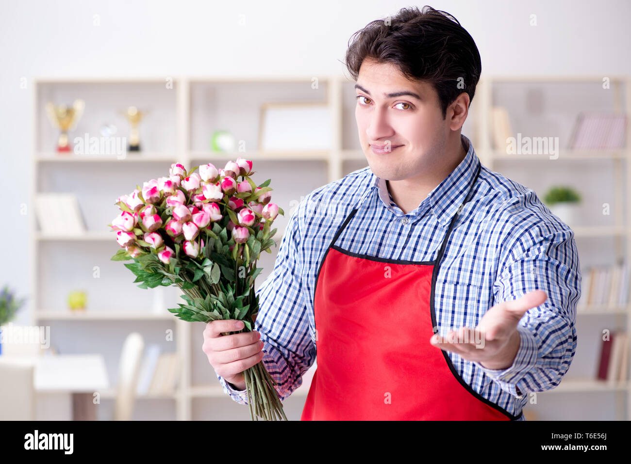 Flower shop assistant offering a bunch of flowers Stock Photo - Alamy