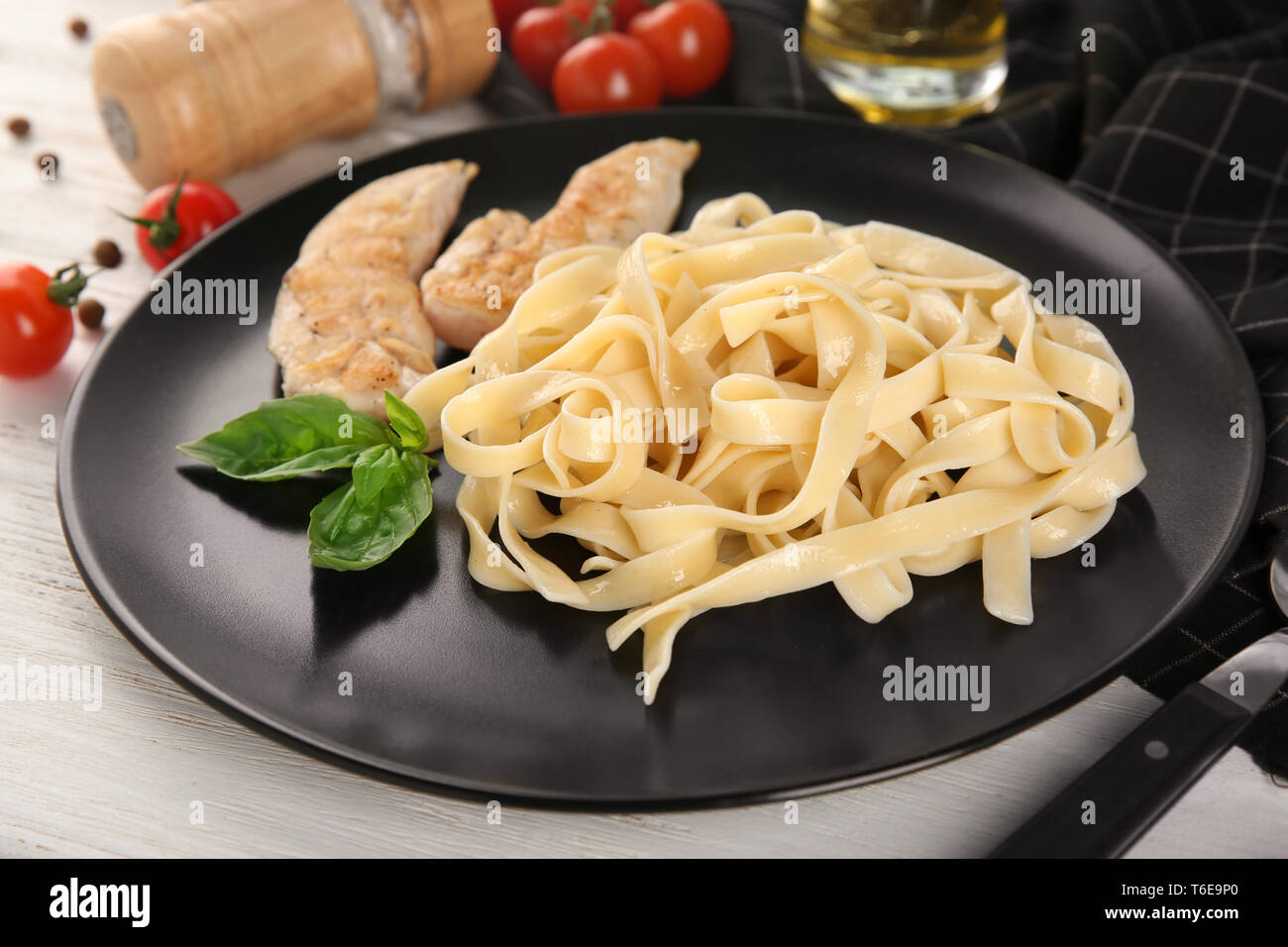 Plate of tasty pasta with chicken fillet on table Stock Photo - Alamy