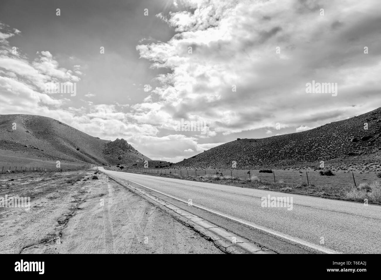 Roadside pull out looking at County road leading into mountains under ...