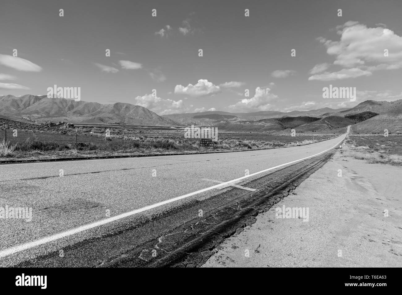 Black and white , long straight road running through countryside to ...