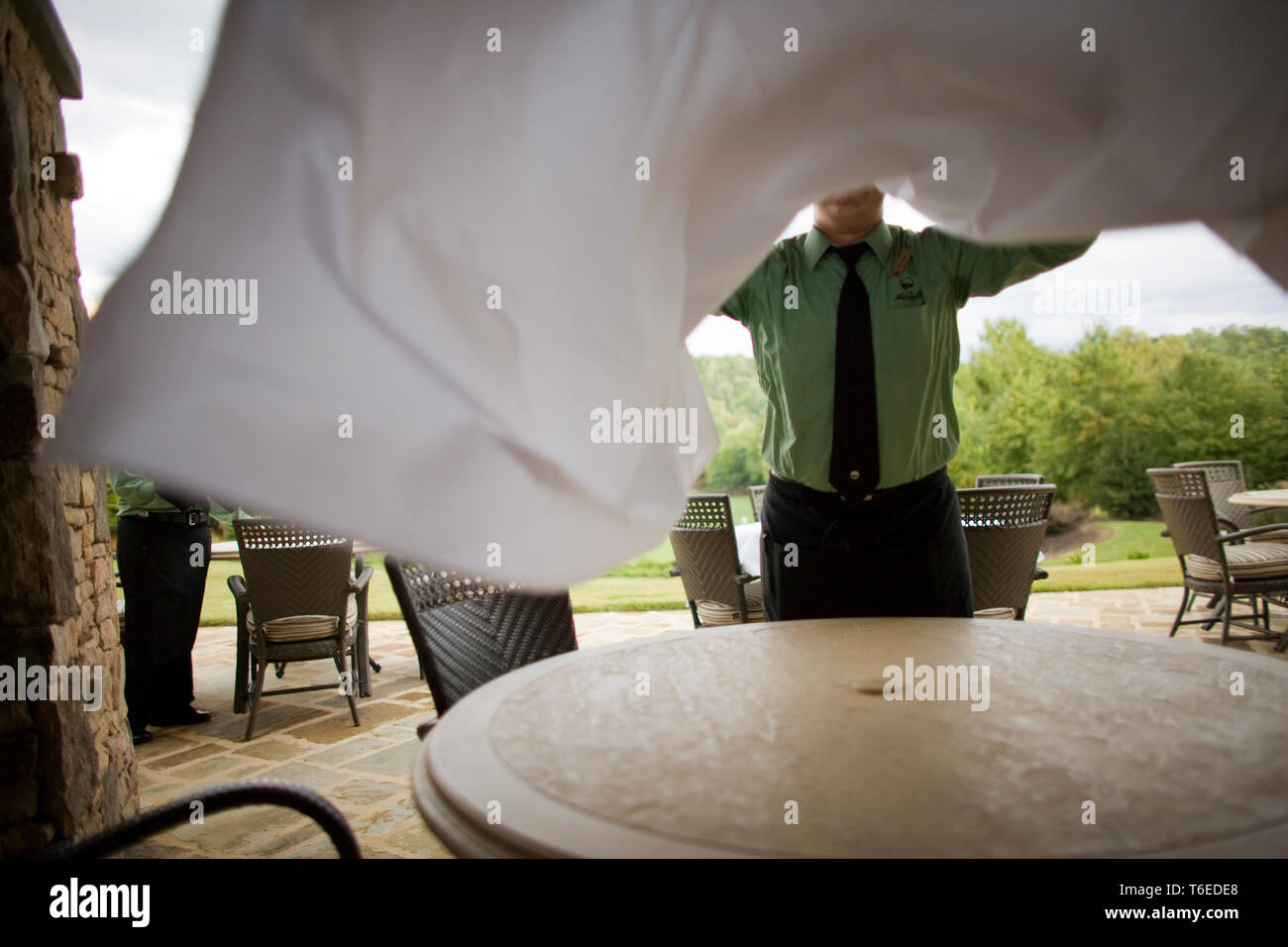 Waiter laying a table cloth on a terrace table of a restaurant Stock ...
