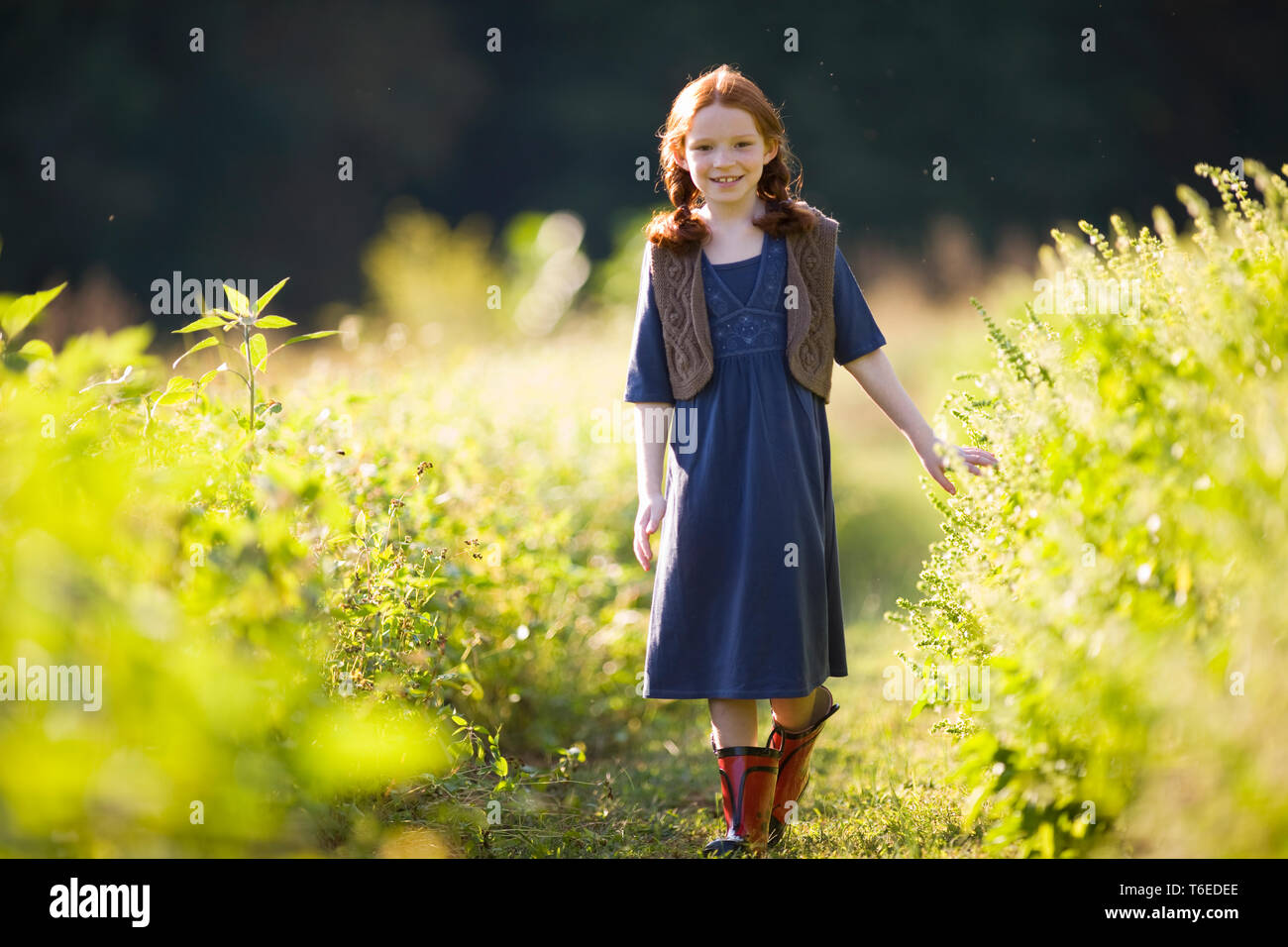 Portrait of a young girl walking through a field Stock Photo - Alamy