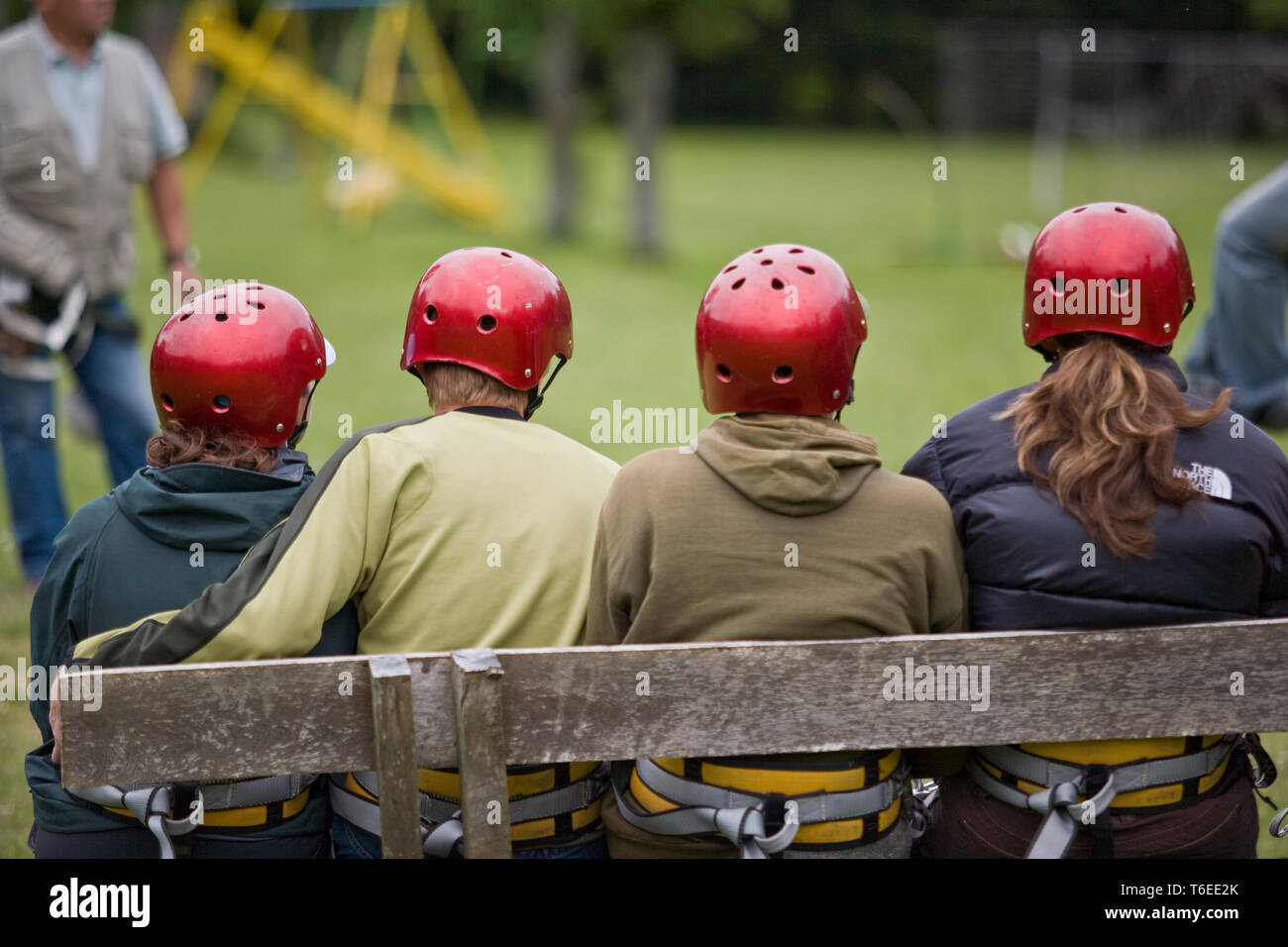 Group of people wearing red helmets sitting next to each other on a ...