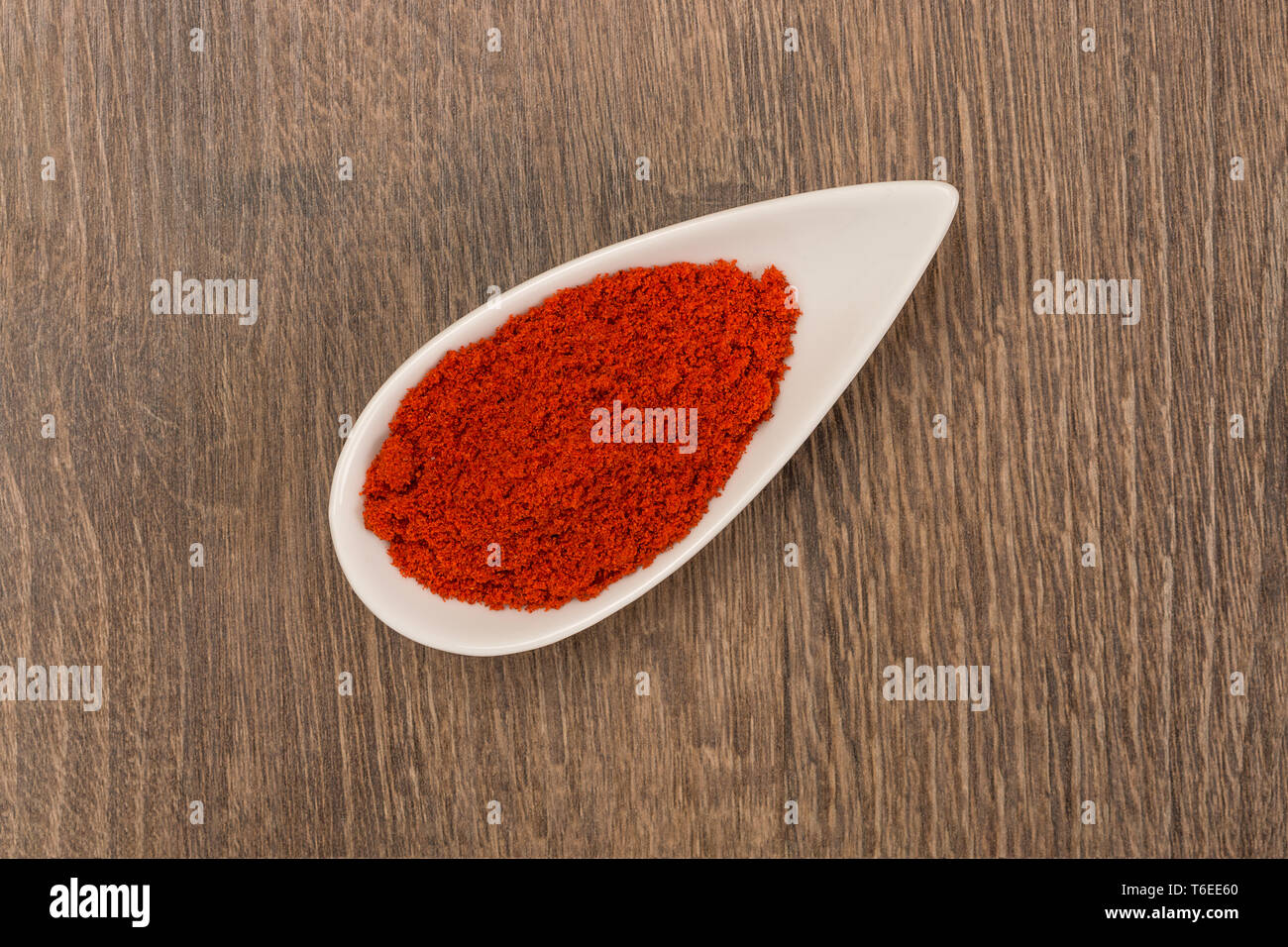 Red pepper powder over wood background Stock Photo - Alamy