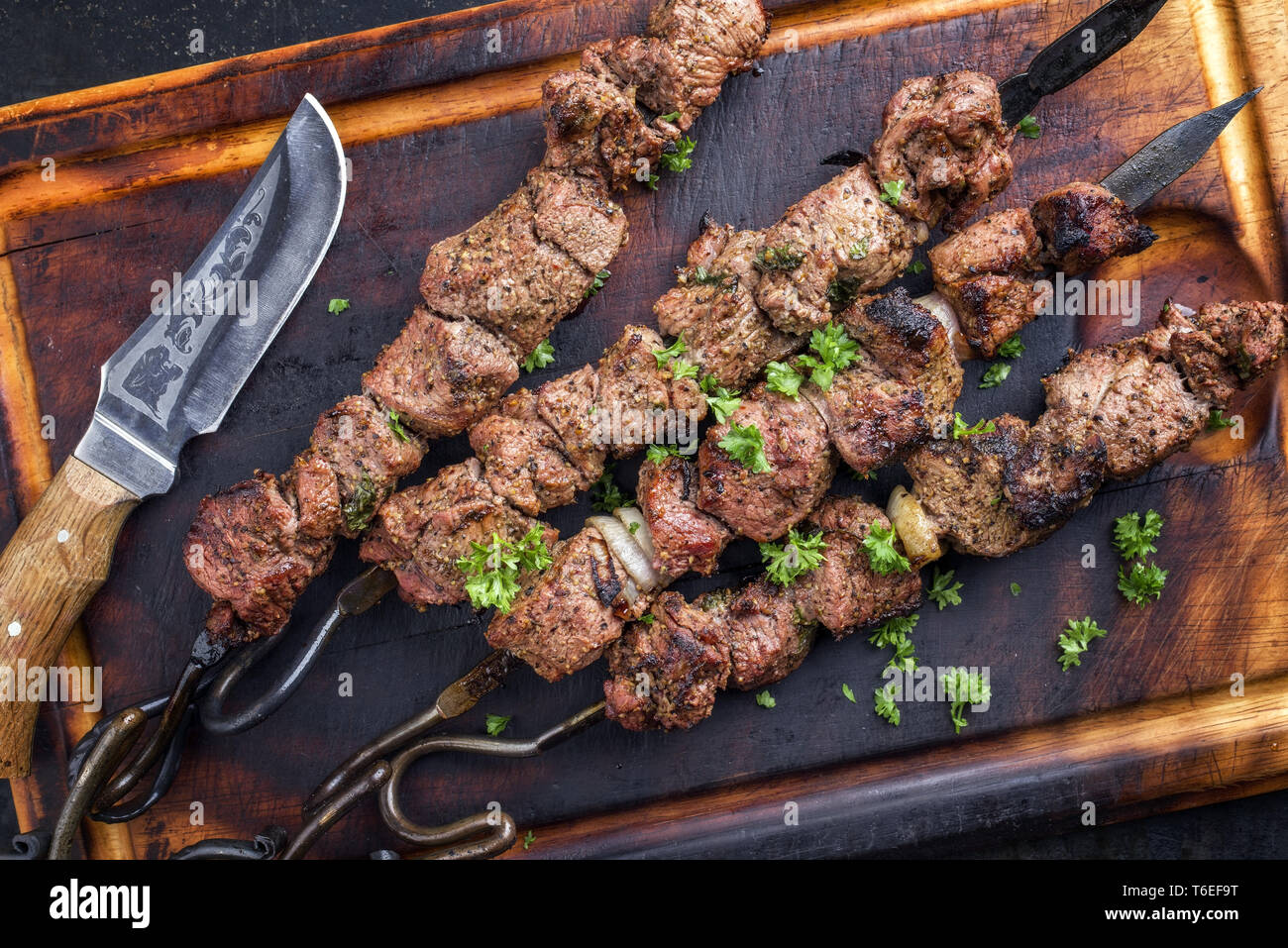 Traditional Russian shashlik on a barbecue skewer as top view on an old ...