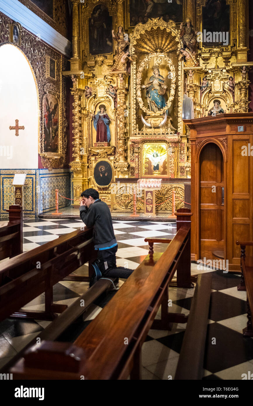 Kneeling man praying inside the Basilica Cathedral of Lima, Peru Stock ...