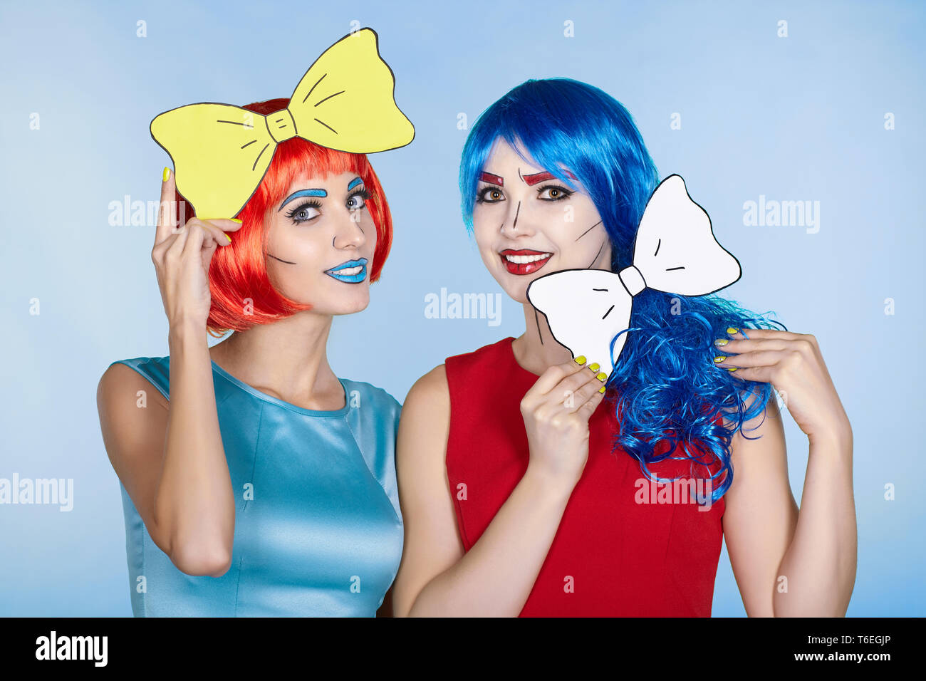 Females in red and blue wigs on blue background. Girls with yellow bow ...