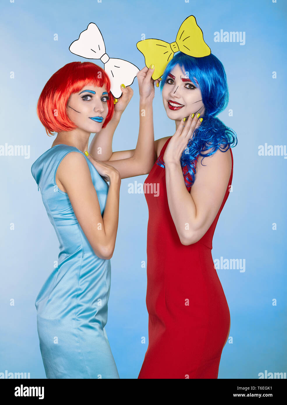 Females in red and blue wigs on blue background. Girls with yellow bow ...