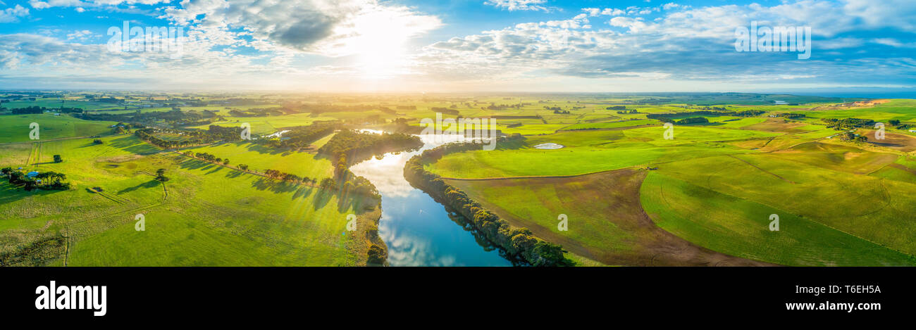 Aerial panoramic landscape of scenic sunset over river and grasslands ...