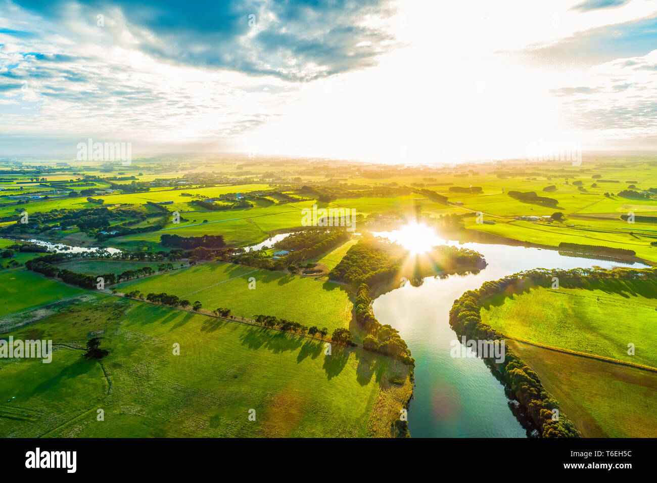 Bright sunset over scenic river in lush green countryside Stock Photo ...
