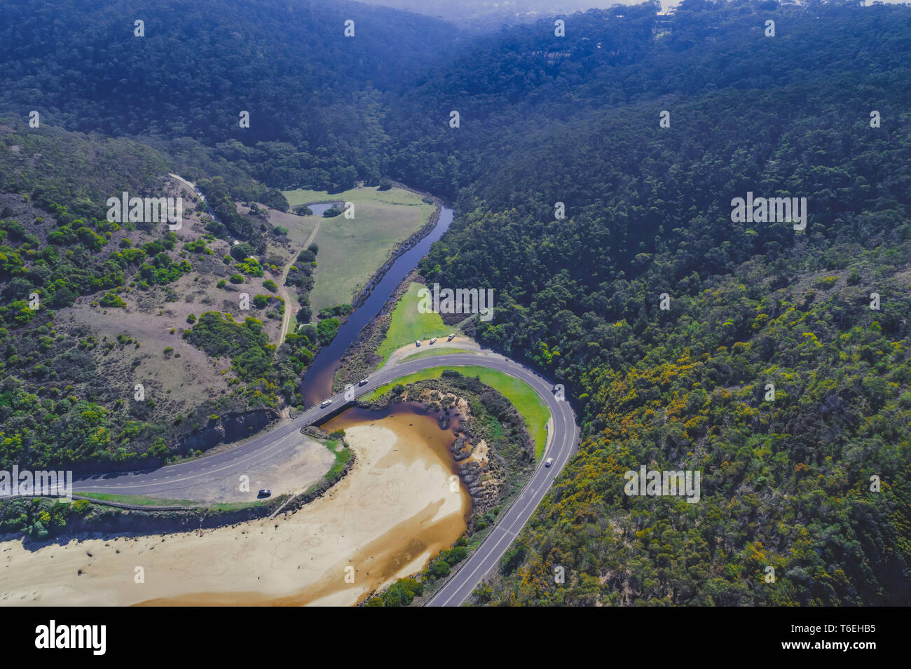 Aerial view of Great Ocean Road bend and forested hills in Victoria ...