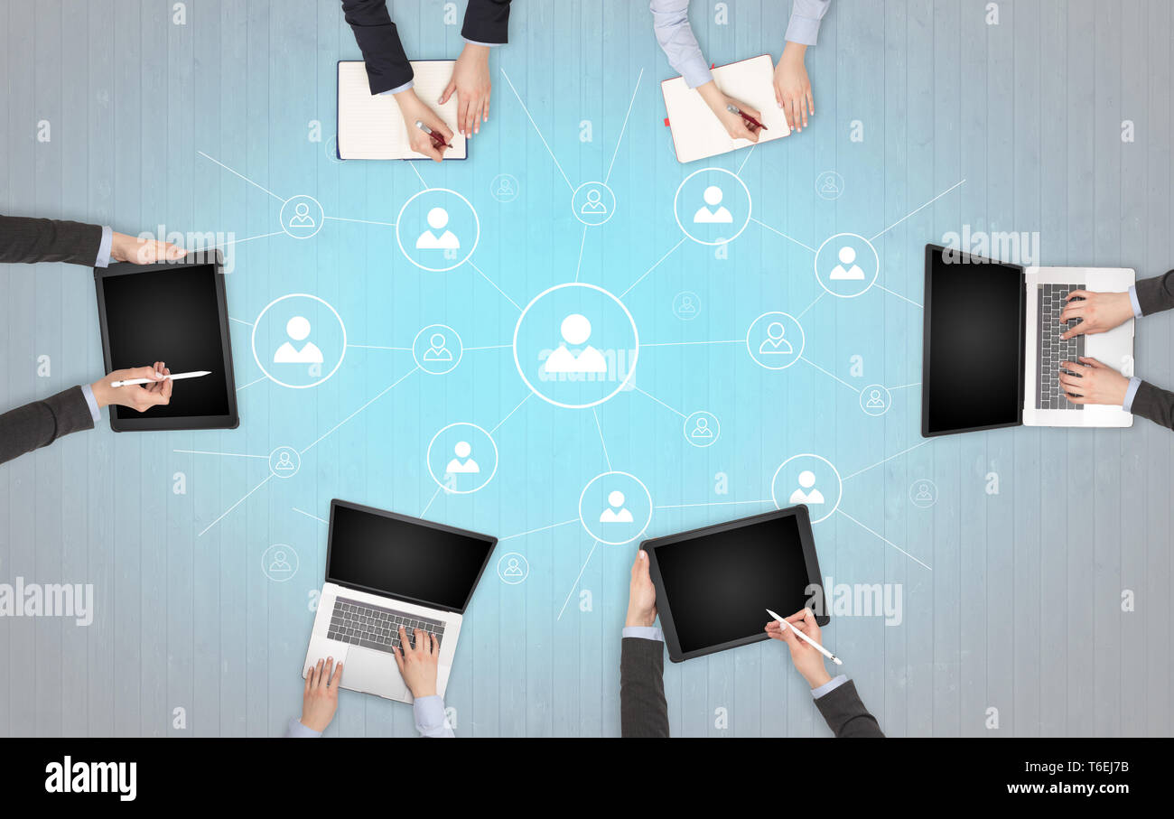 Group of people with devices in hands working in team on tablets ...