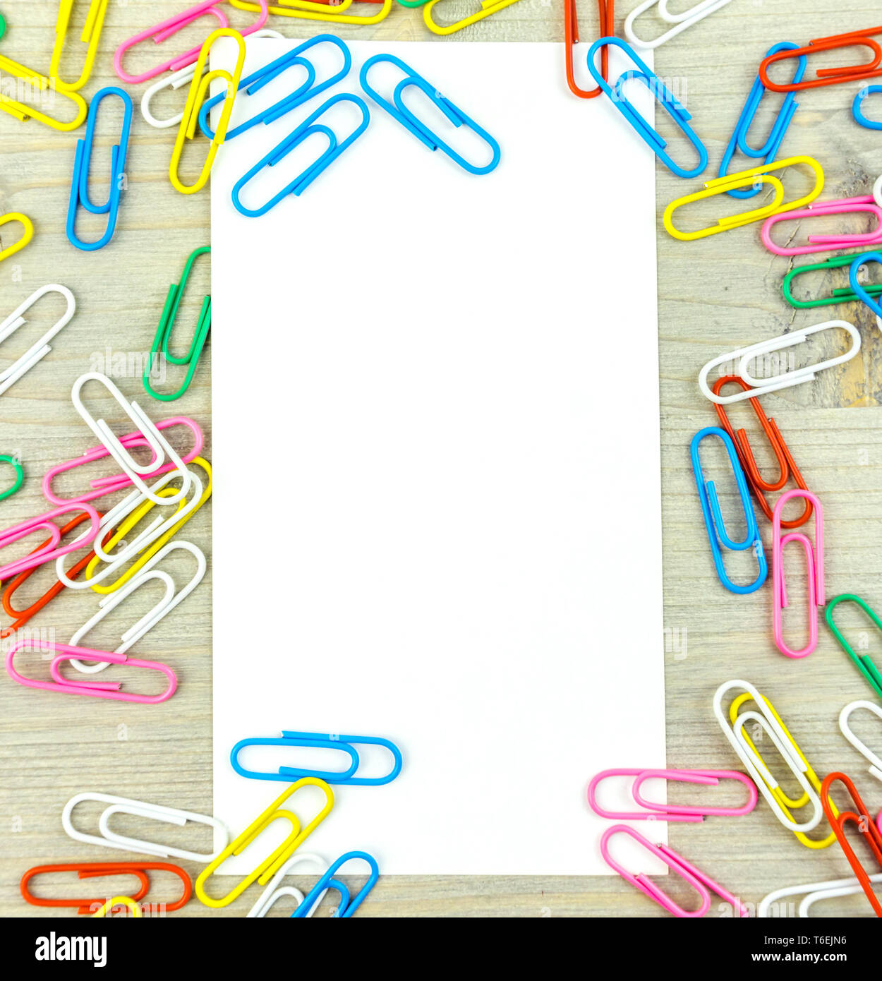 Note with set of colorful paper clips on wooden background with copy ...