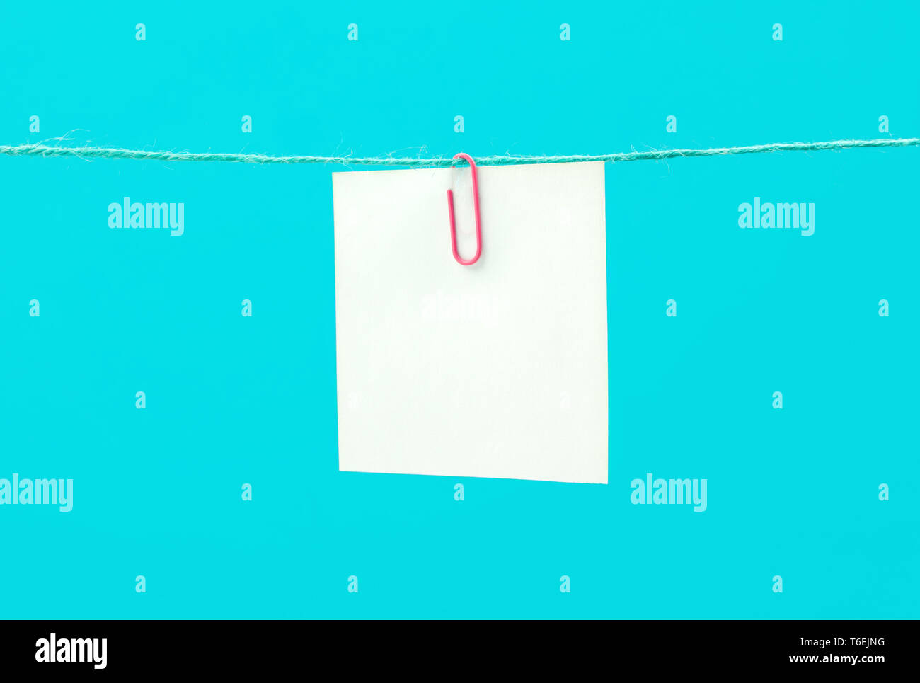 White empty paper sheet on the string with paperclip over blue ...