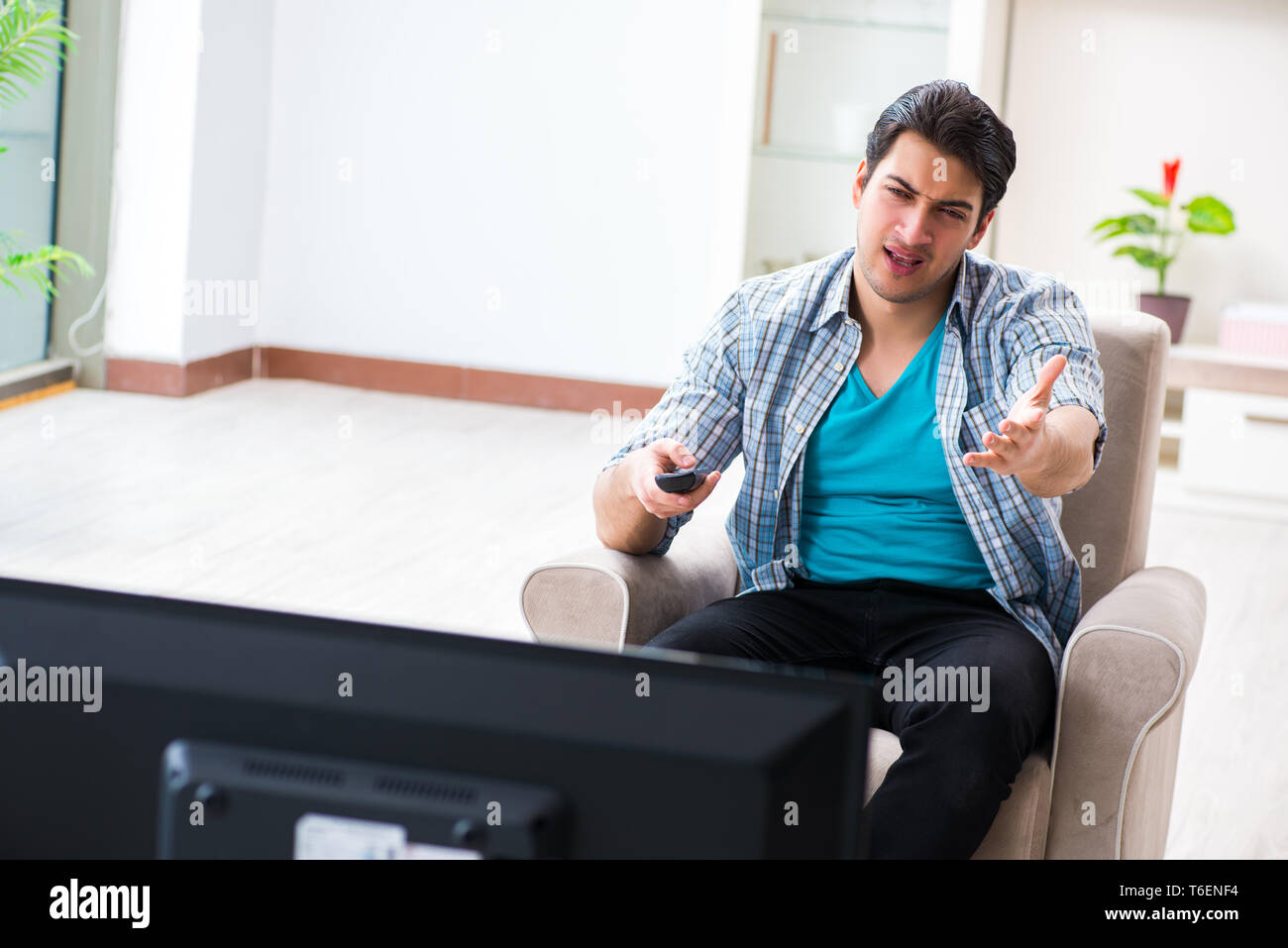 Man watching tv at home Stock Photo - Alamy