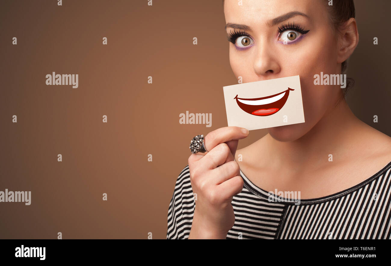 Person holding card in front of his mouth with ironic smile Stock Photo ...