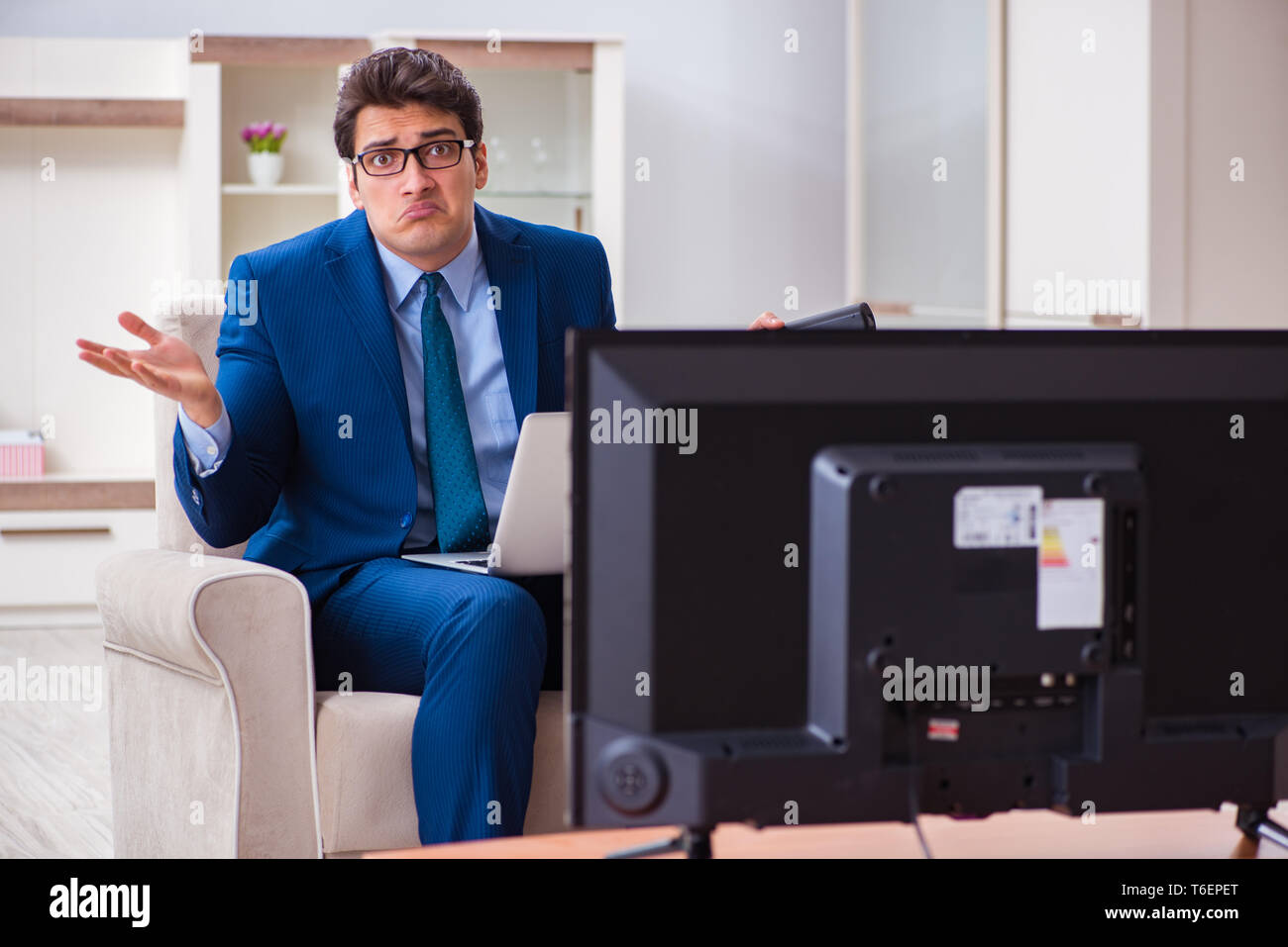 Businesman watching tv in office Stock Photo - Alamy
