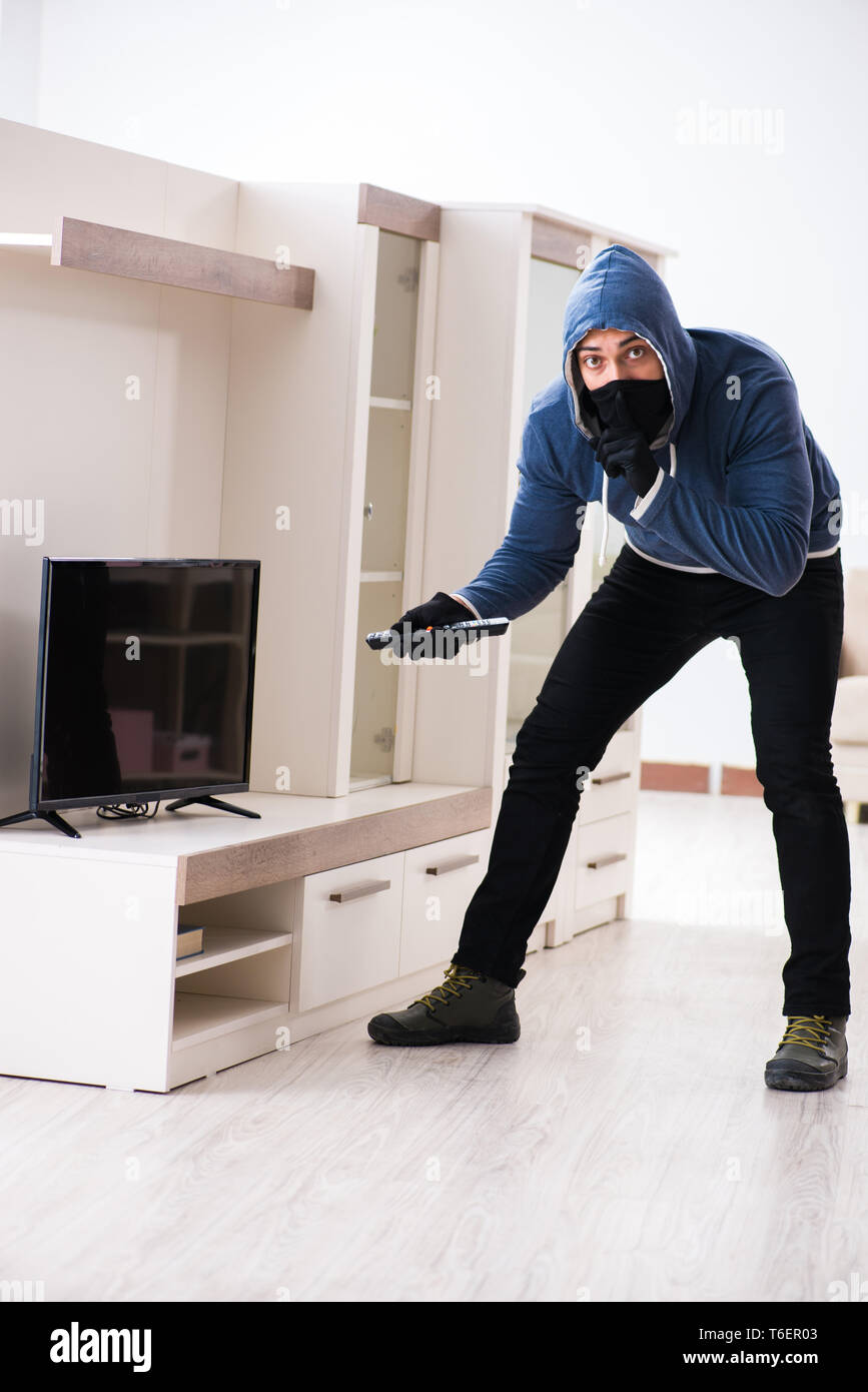 Man burglar stealing tv set from house Stock Photo - Alamy