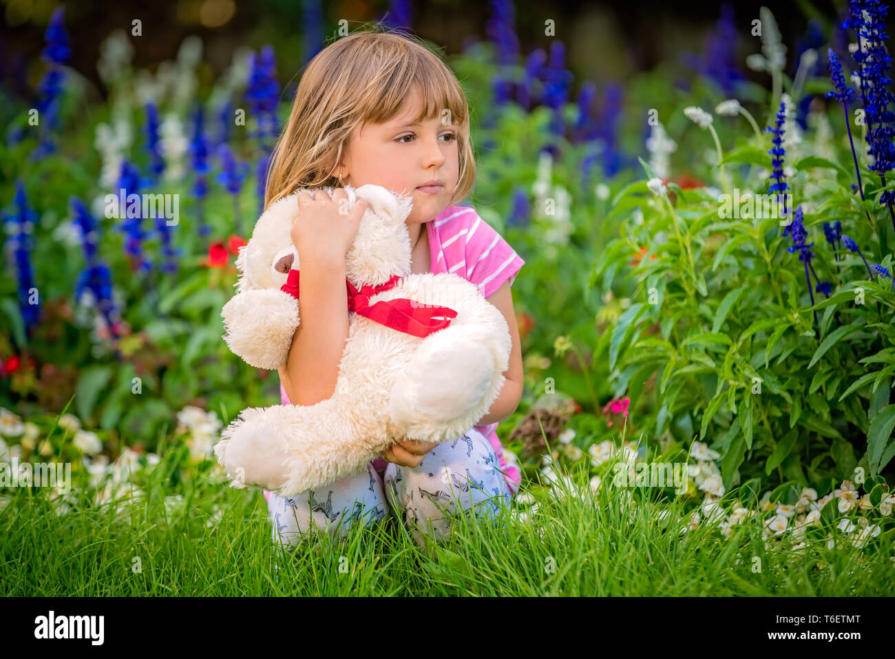Adorable girl hugging her teddy bear in summer park Stock Photo - Alamy