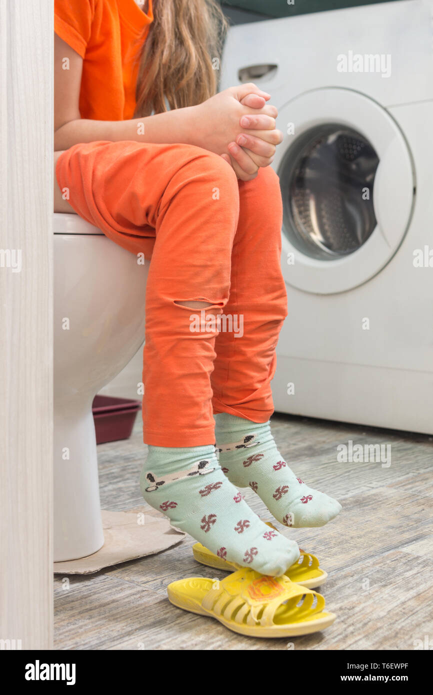 Little girl is sitting on the toilet in the bathroom Stock Photo - Alamy