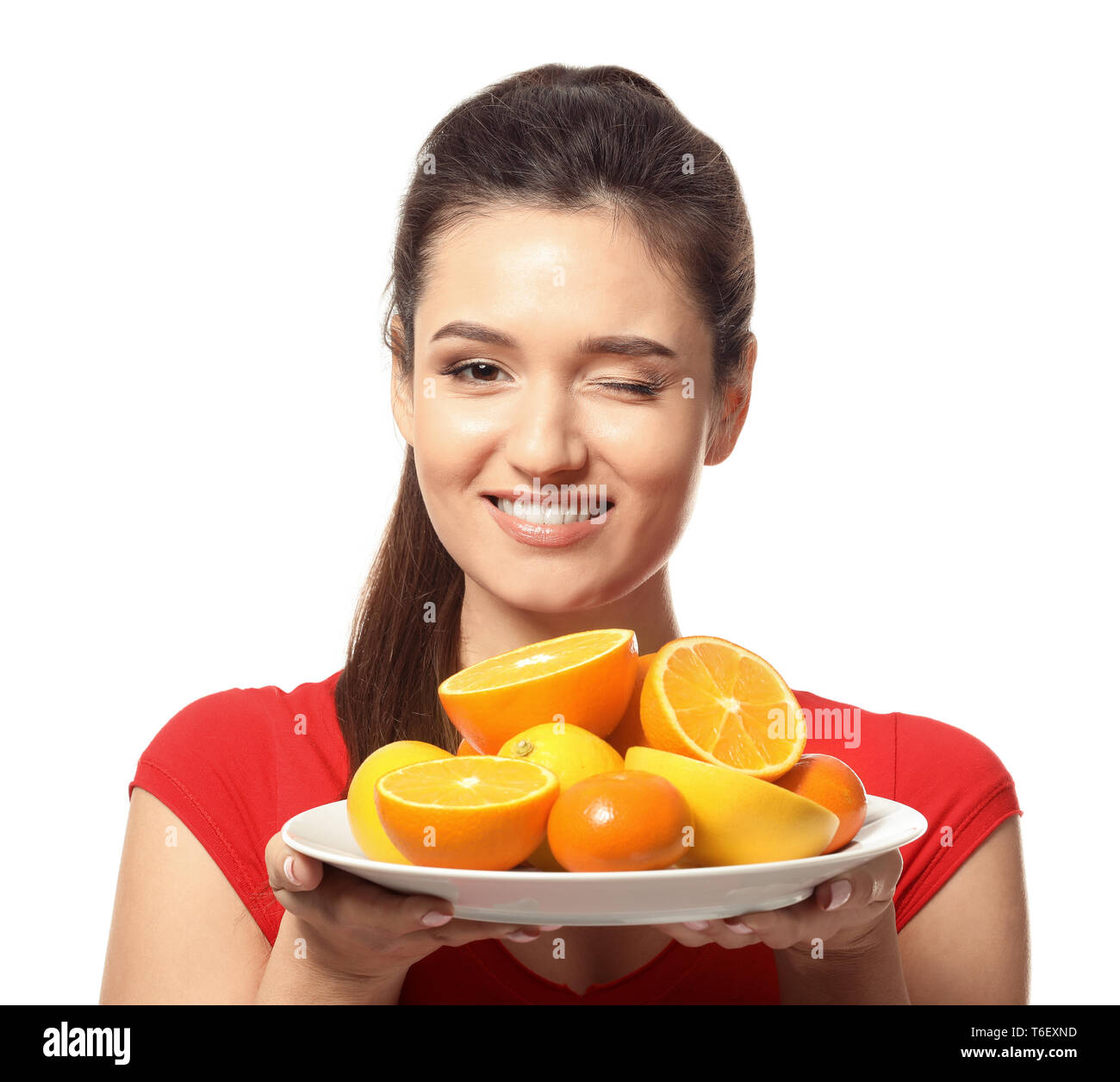 Beautiful young woman with plate full of citrus fruits on white ...