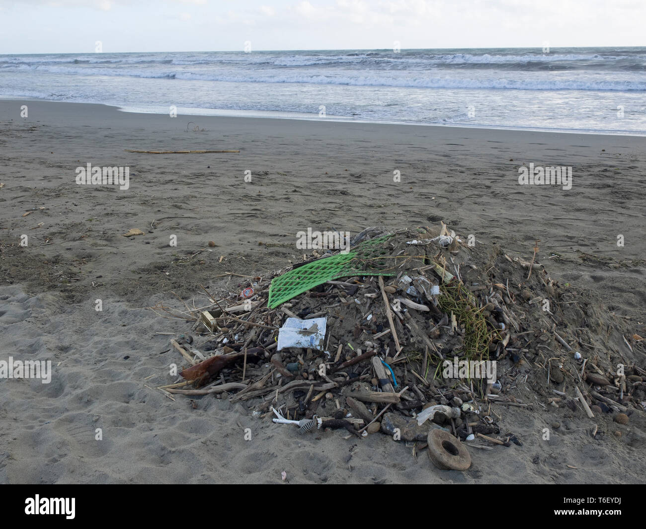 ocean pollution: waste collected on a sandy beach: lots of objects ...