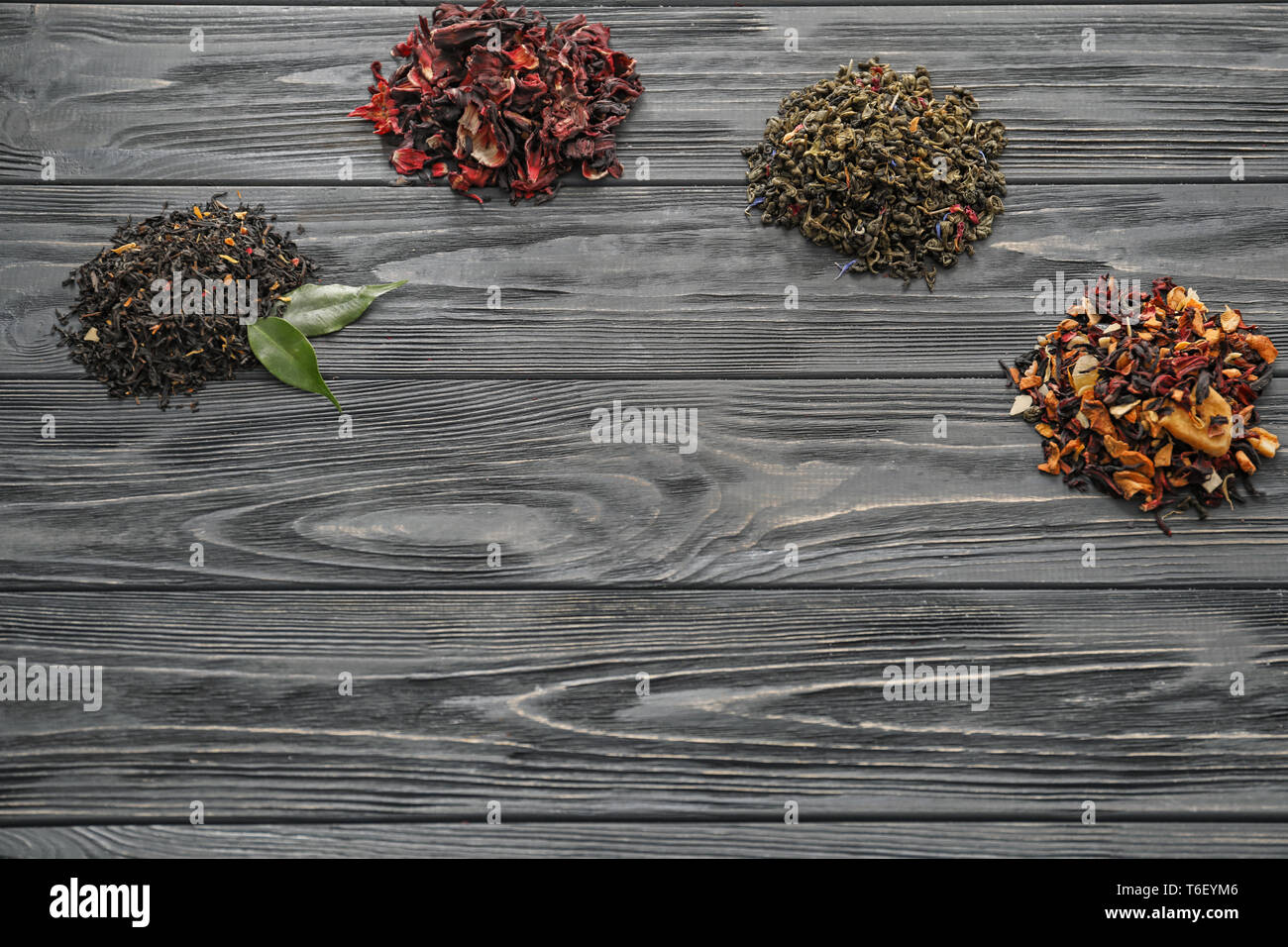 Different types of dry tea leaves on wooden background Stock Photo - Alamy