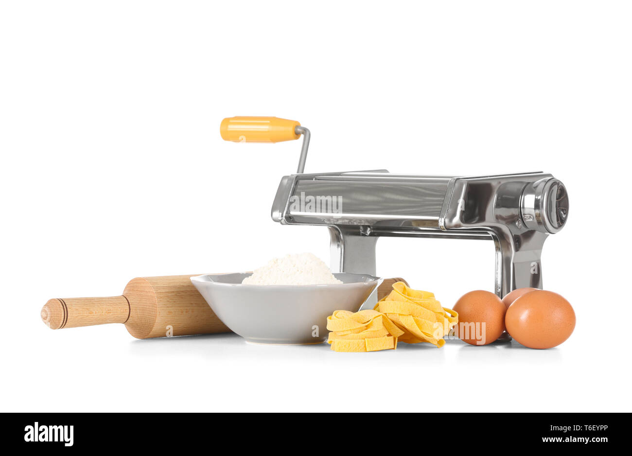 Metal pasta machine and products on white background Stock Photo - Alamy