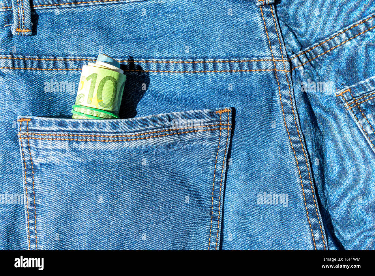 Roll of euro banknotes in a pocket Stock Photo - Alamy